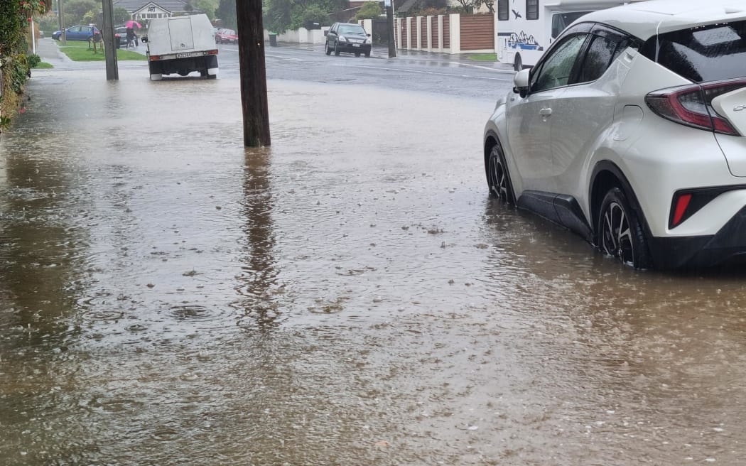 In pictures: Huge slip tears through street, Dunedin roads flood | RNZ News