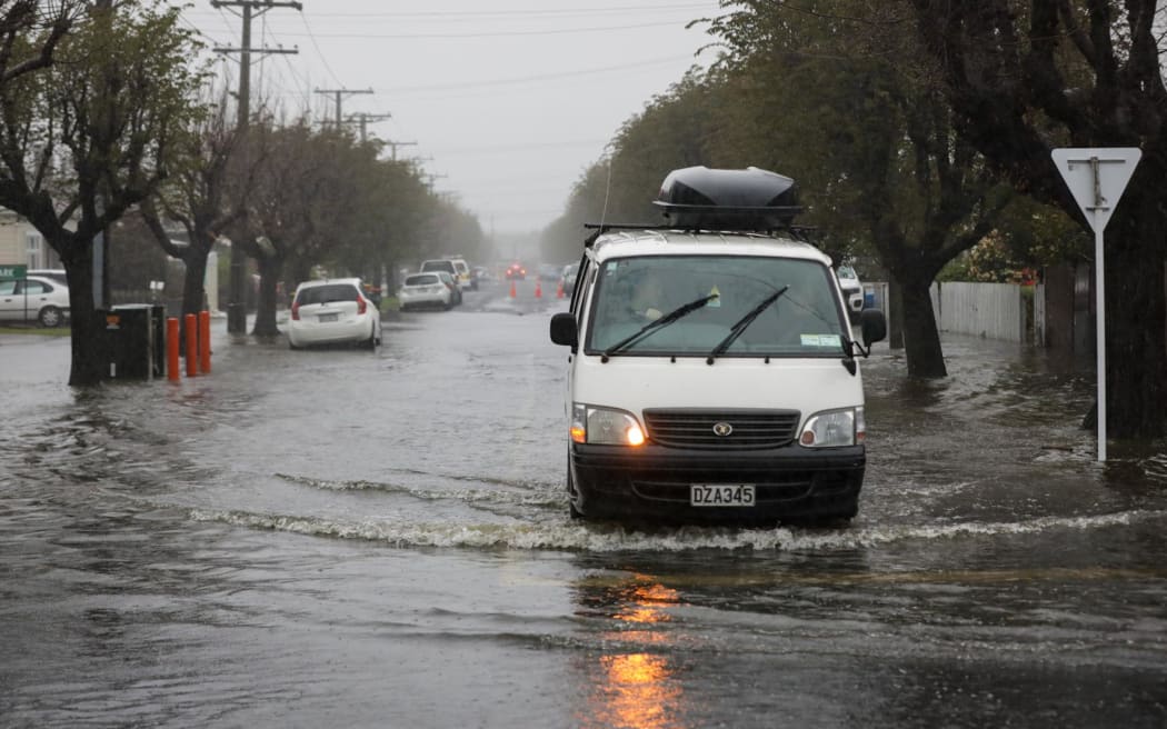 In pictures: Huge slip tears through street, Dunedin roads flood | RNZ News